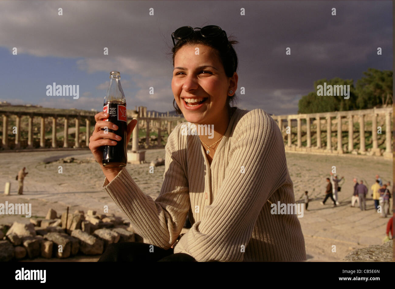 Young woman drinks a coke among the Greco-Roman ruins at Jerash, 48 kms ...