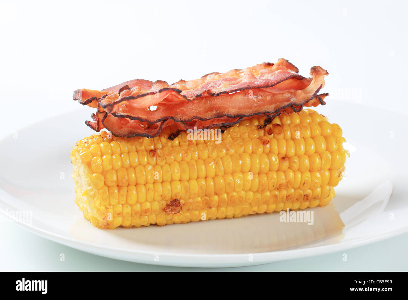 Corn on the cob and rasher of bacon Stock Photo - Alamy