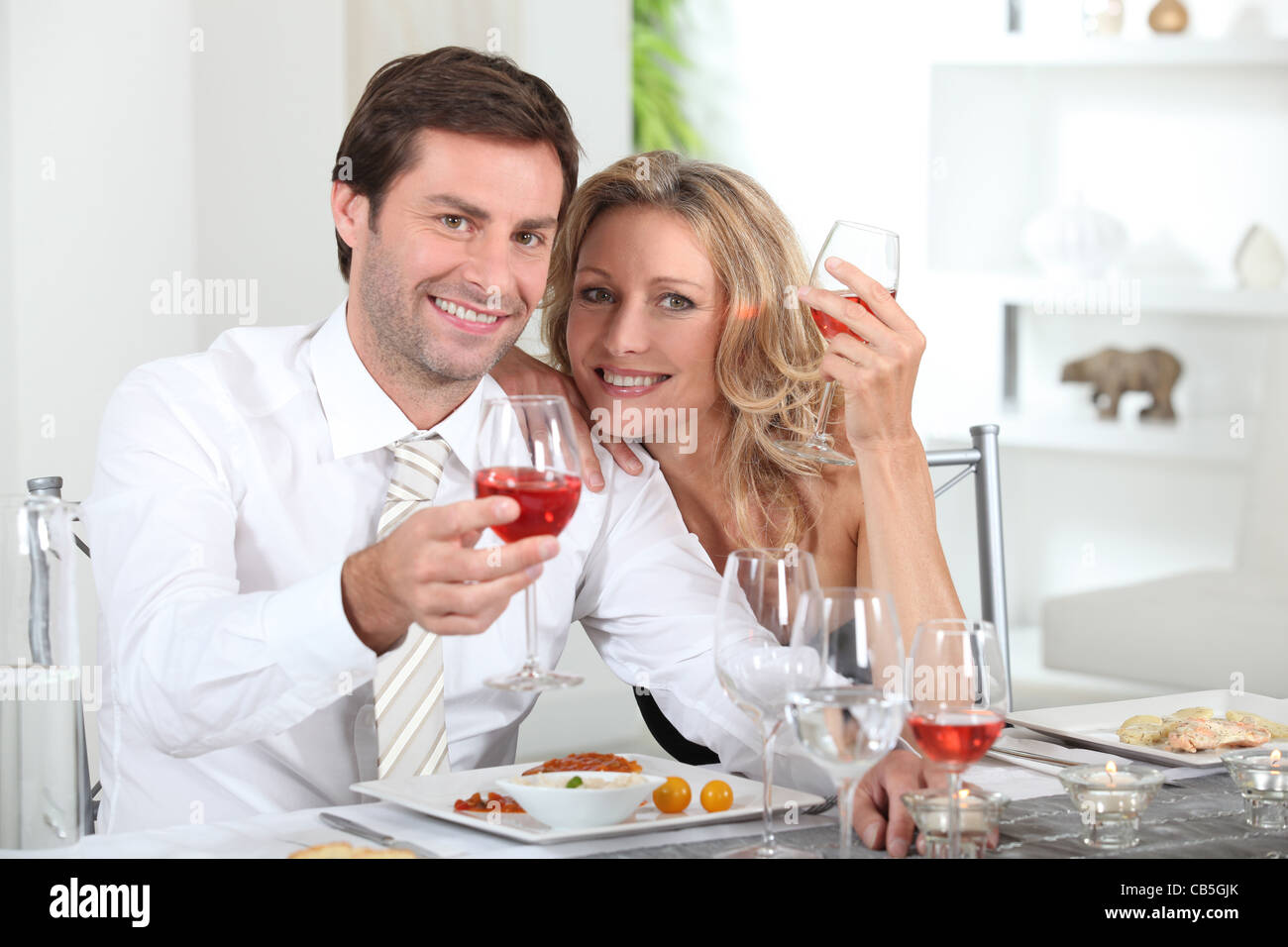 Happy couple eating meal at table Stock Photo - Alamy