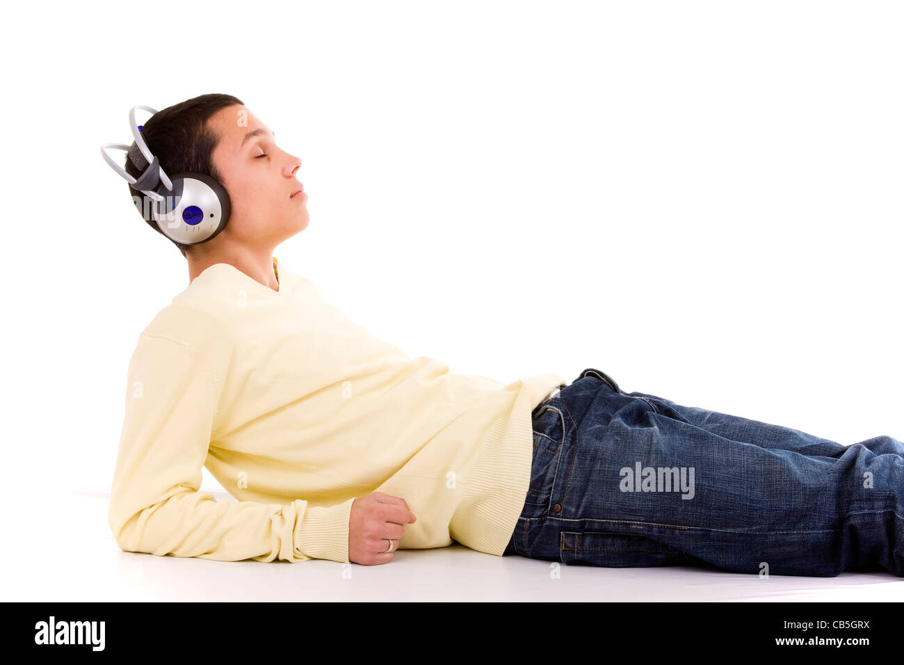 young man lie down on the floor relaxing at the sound of good music ...