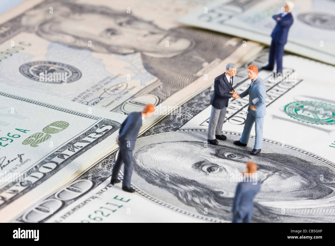 miniature businessman making a financial deal (selective and soft focus ...