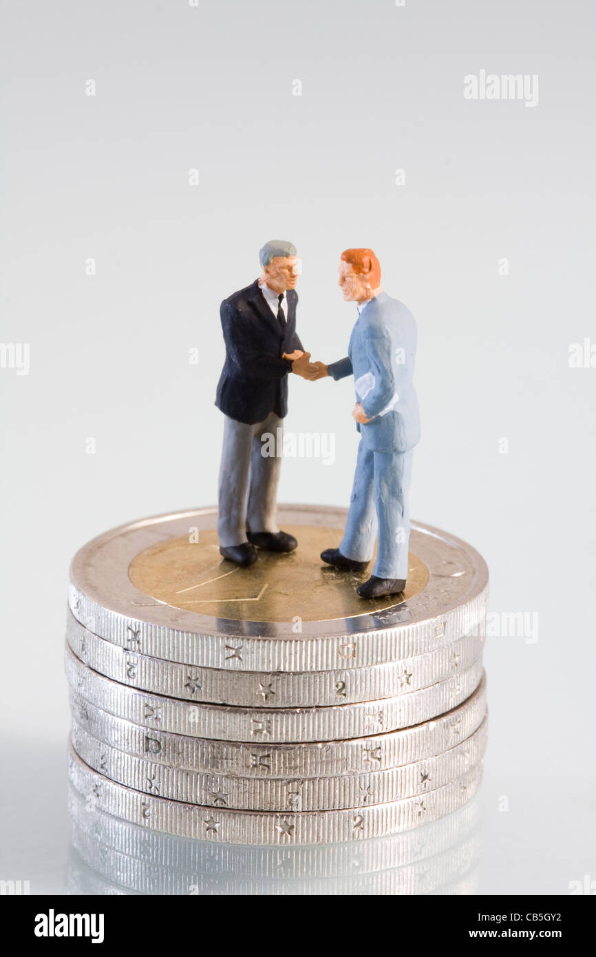 miniature businessman making a money deal (selective and soft focus ...