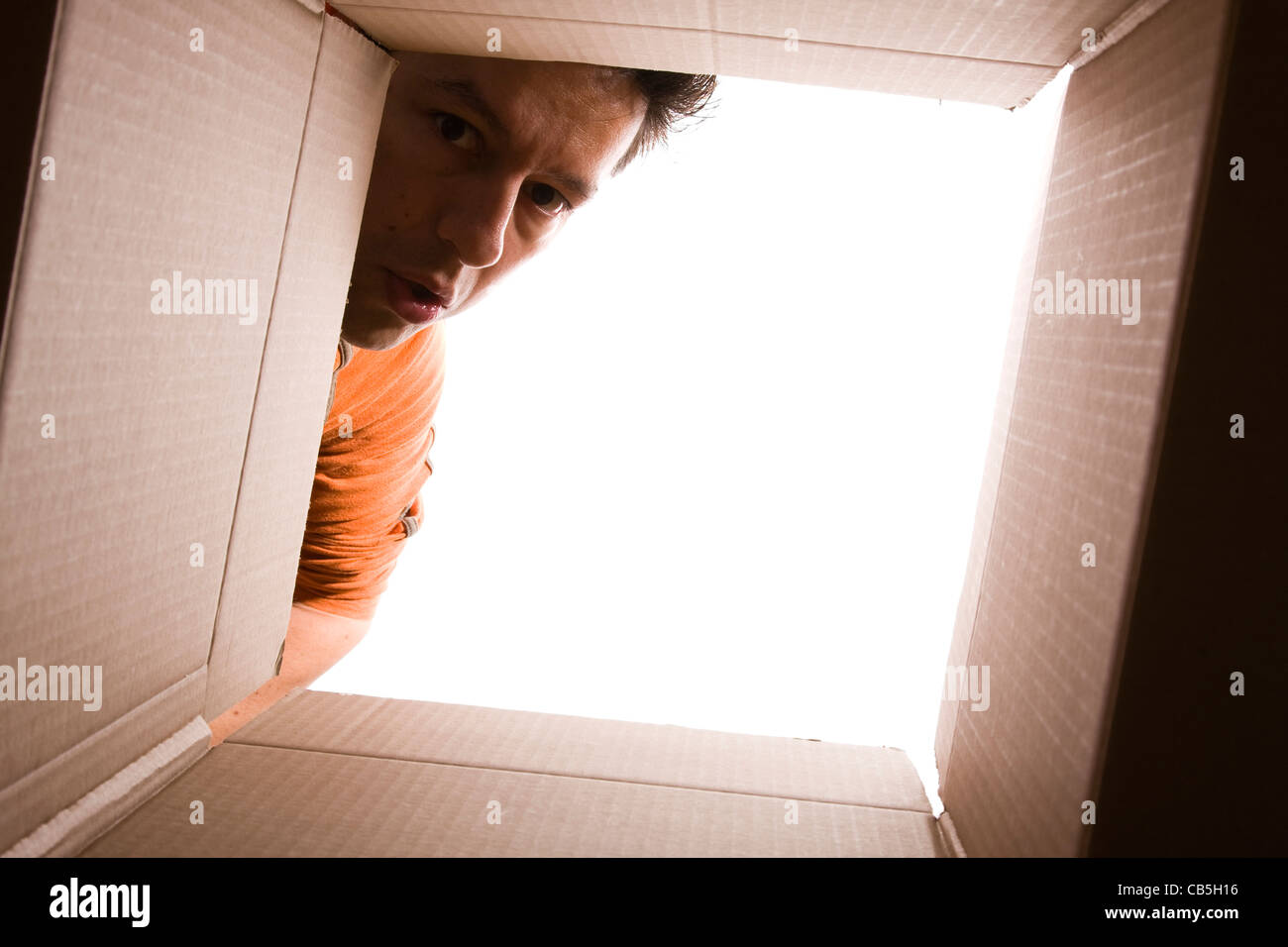 young man looking inside a cardboard box Stock Photo - Alamy