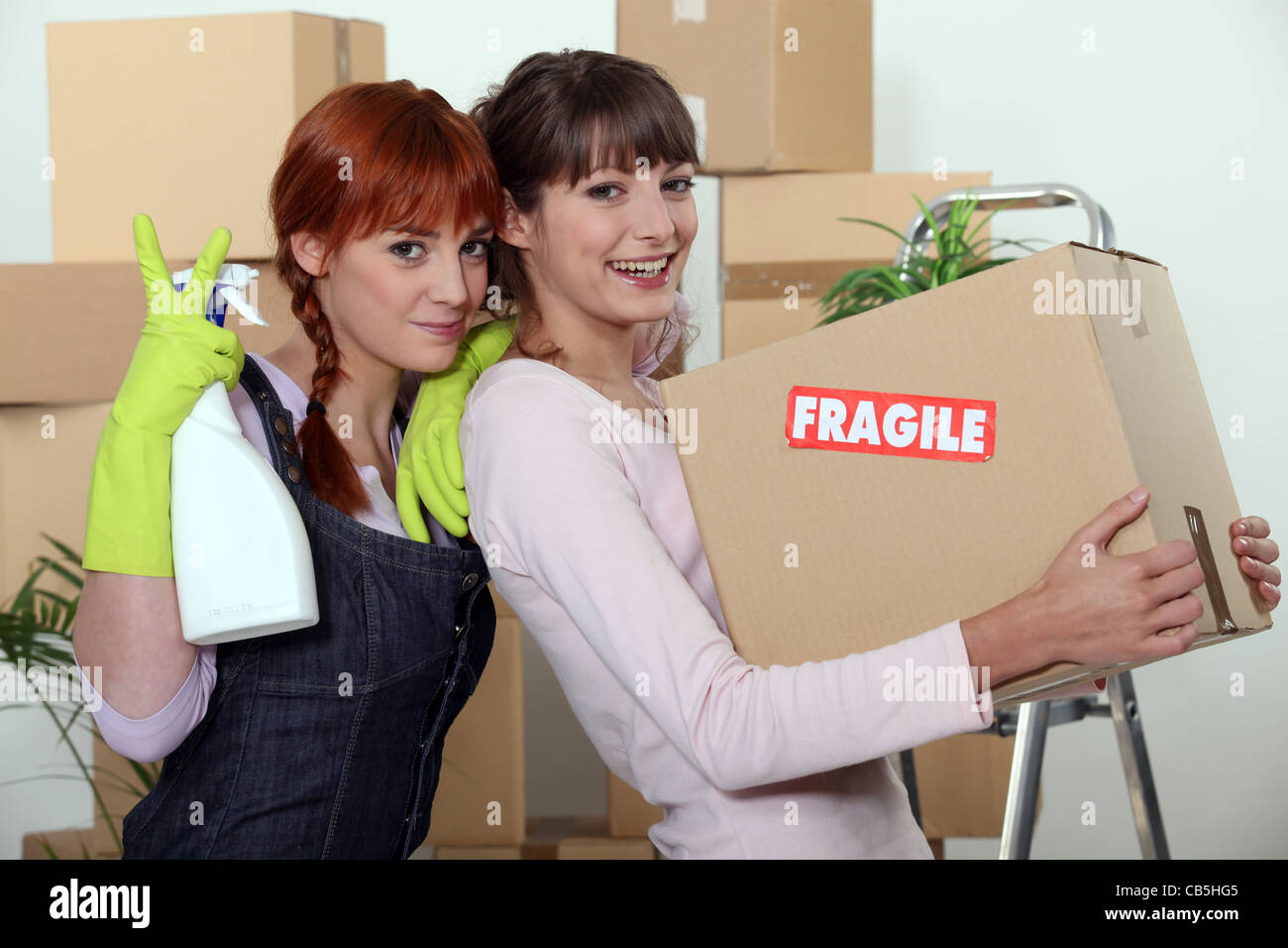 Two female friends moving house Stock Photo - Alamy