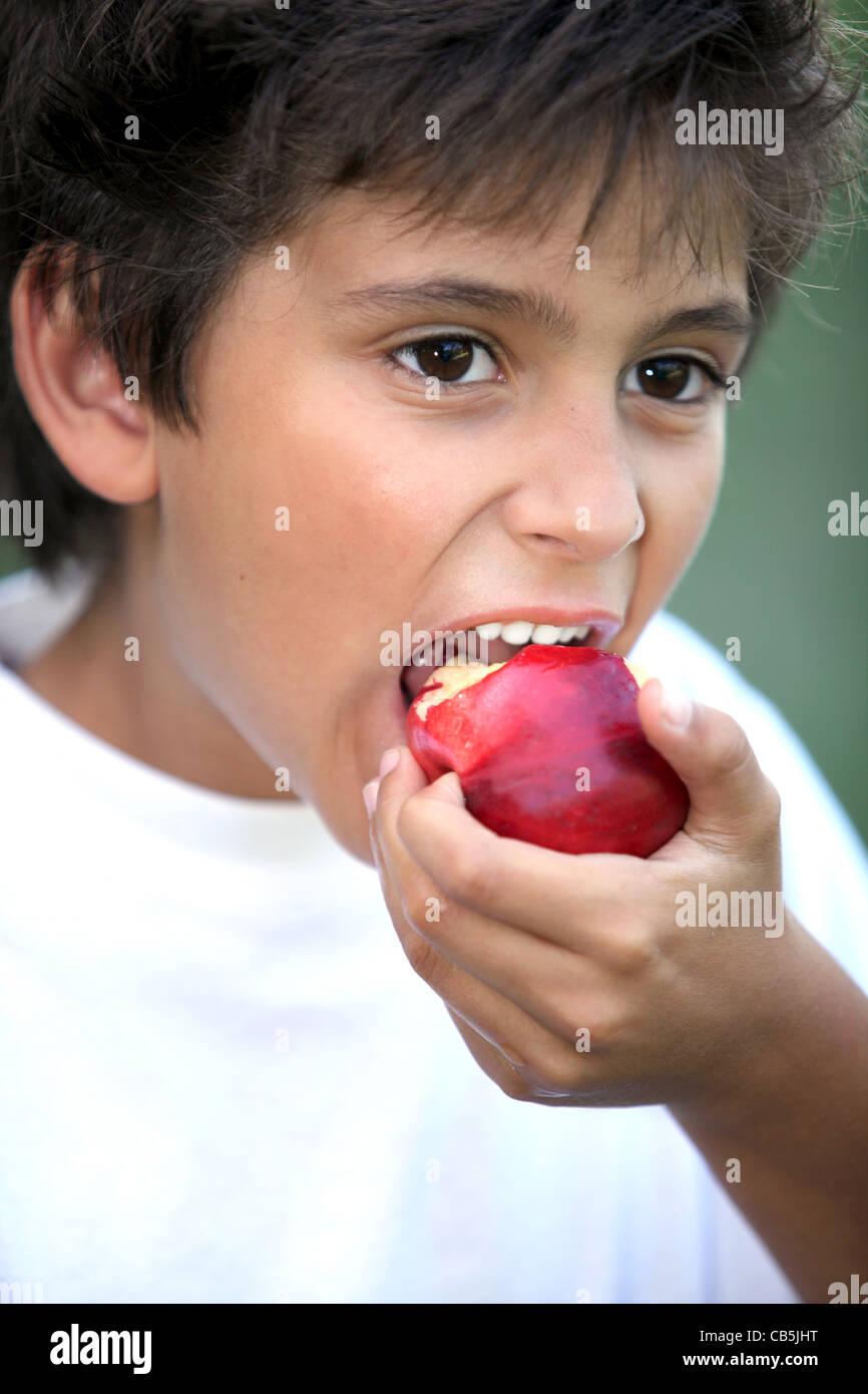 Boy eating an apple Stock Photo - Alamy