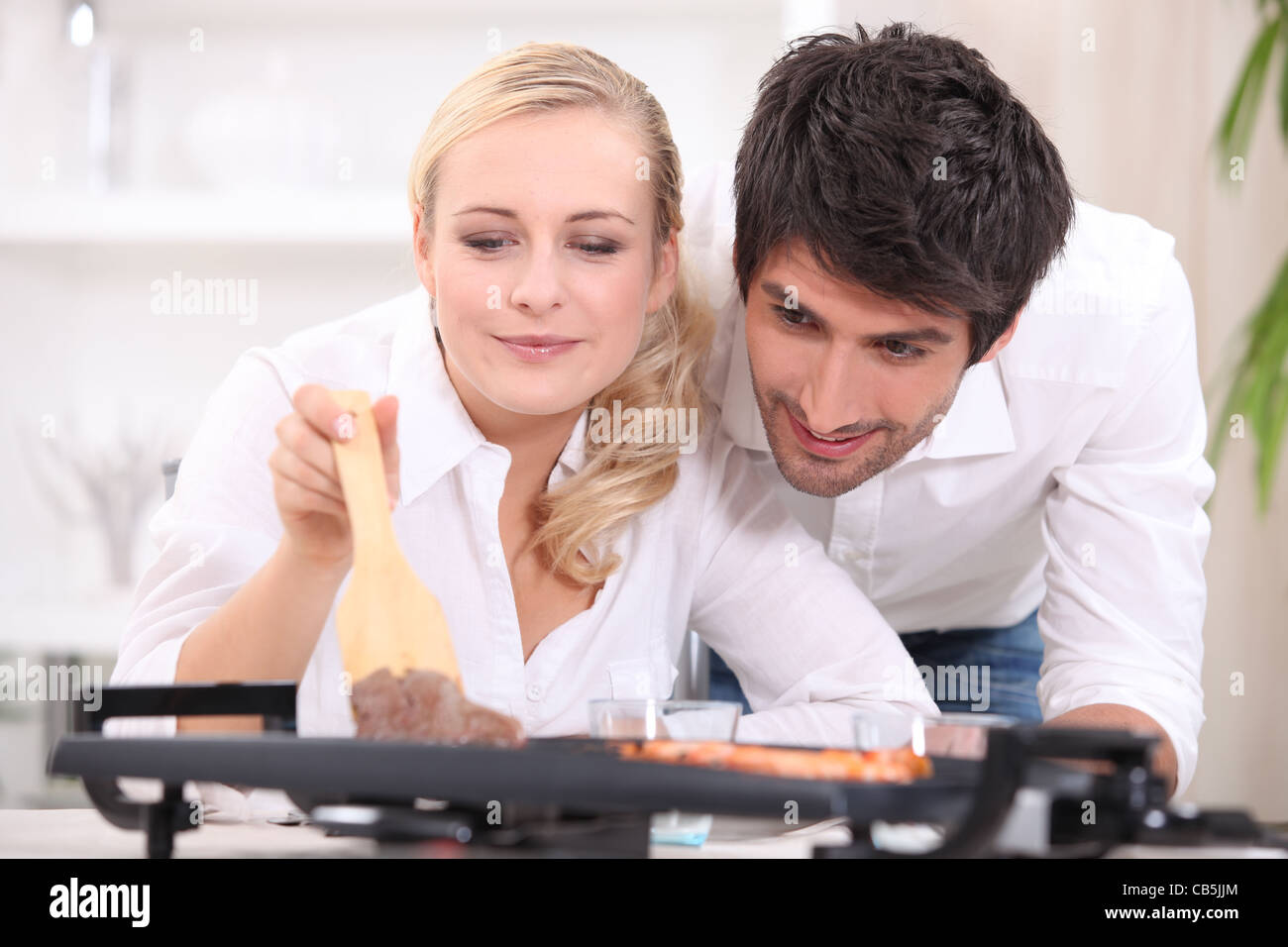 Couple cooking on a table top electric hotplate Stock Photo - Alamy