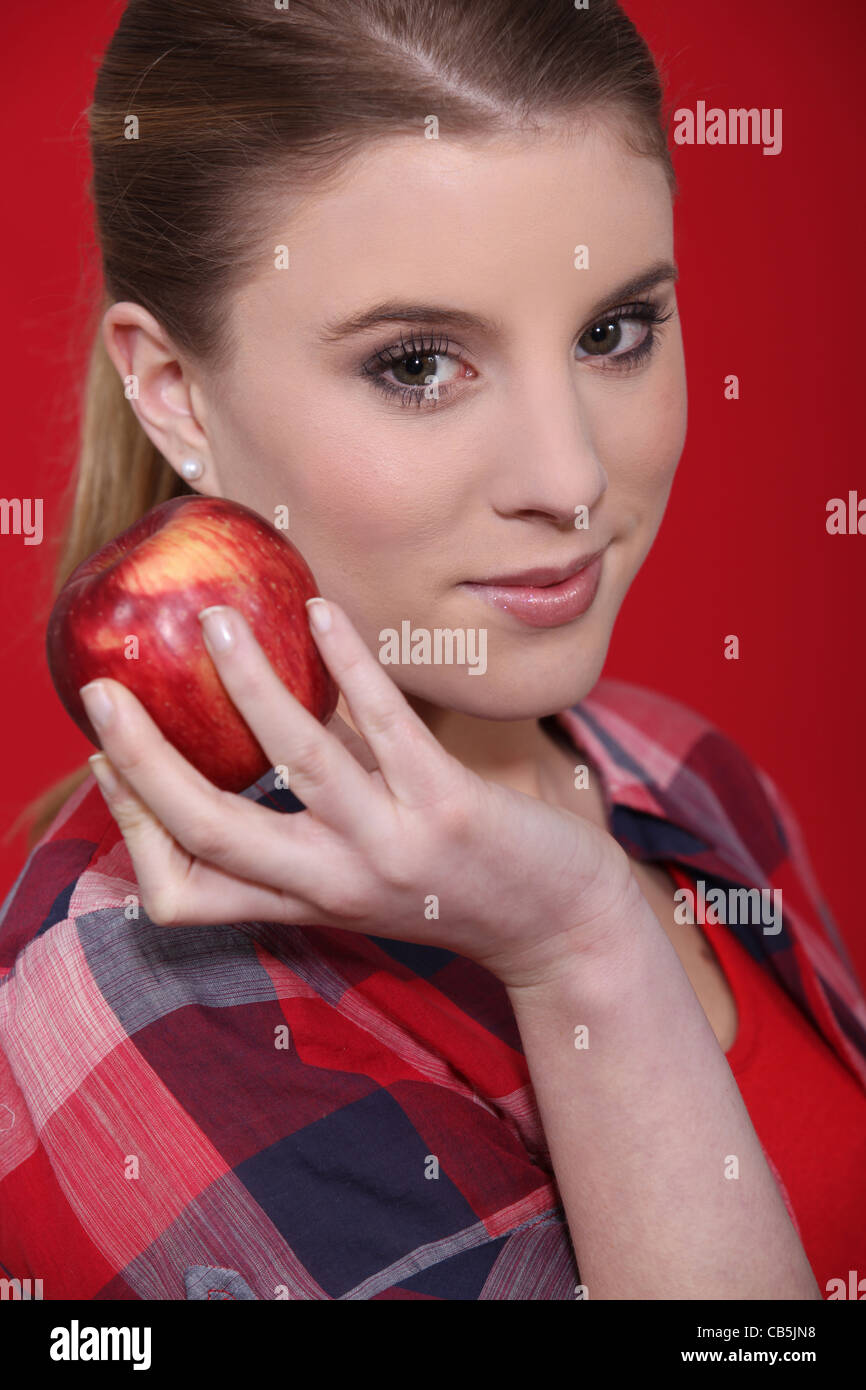 Woman in studio eating red apple Stock Photo - Alamy