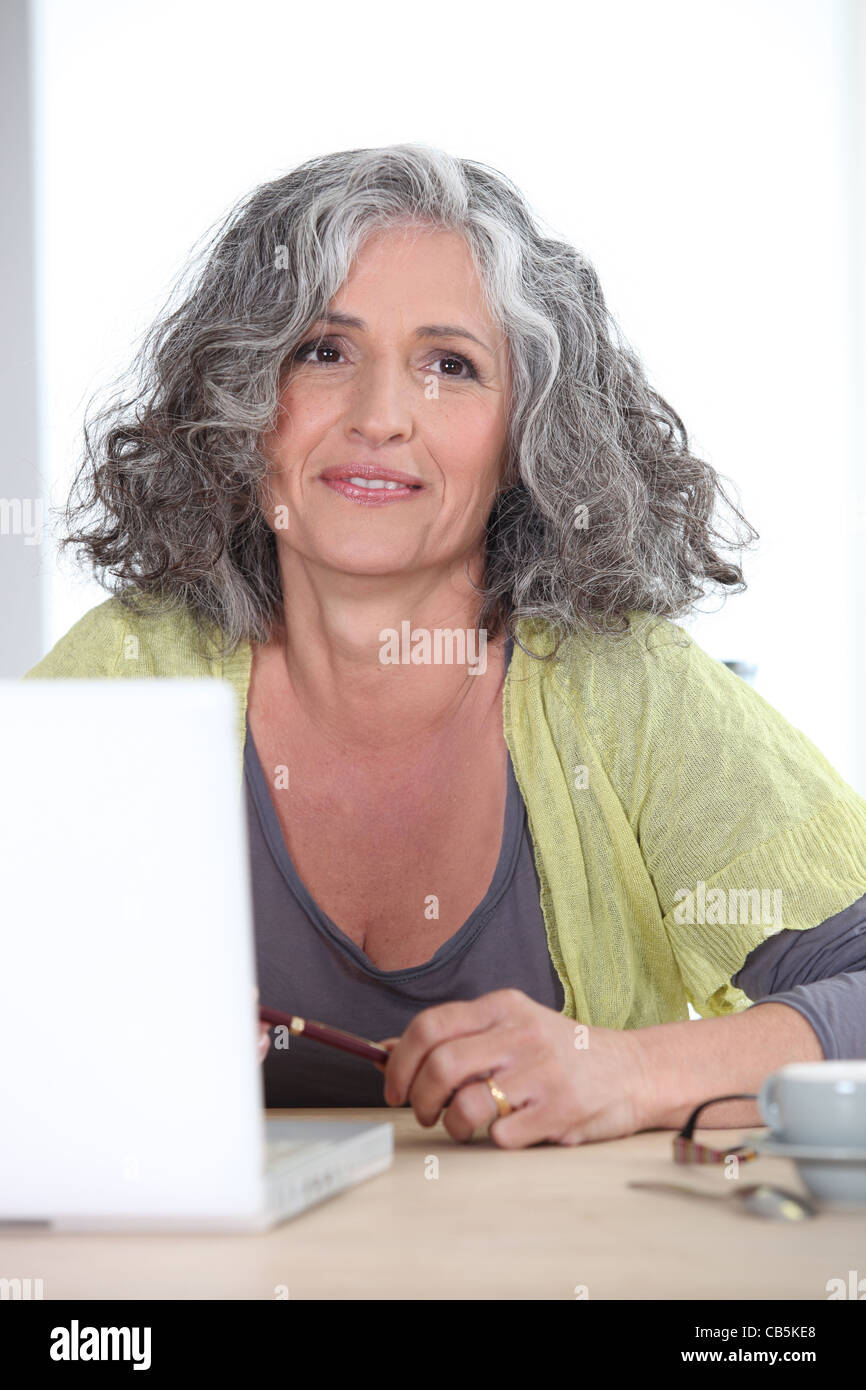 Gray-haired woman in front of laptop computer Stock Photo - Alamy