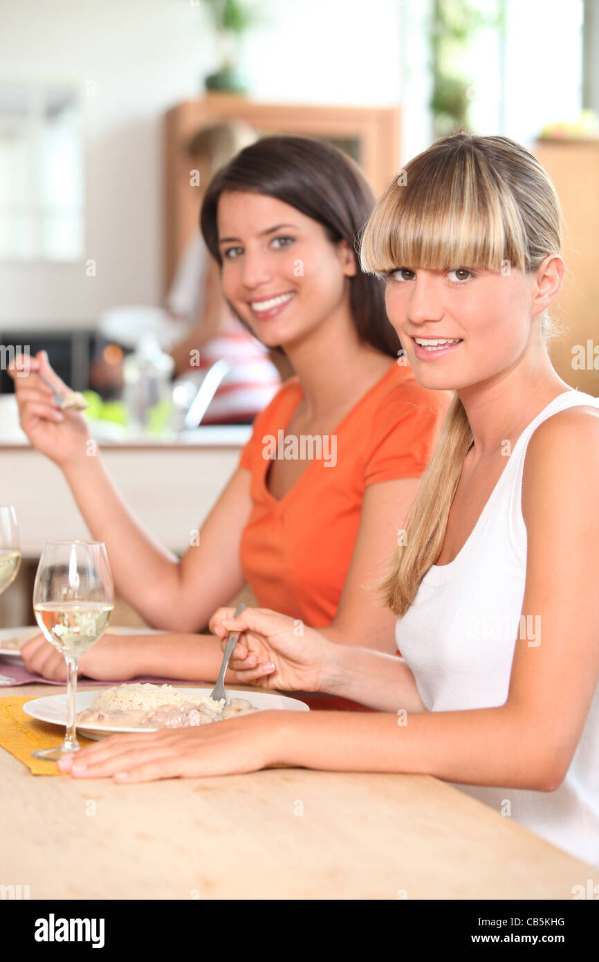 Two female housemates eating at home Stock Photo - Alamy