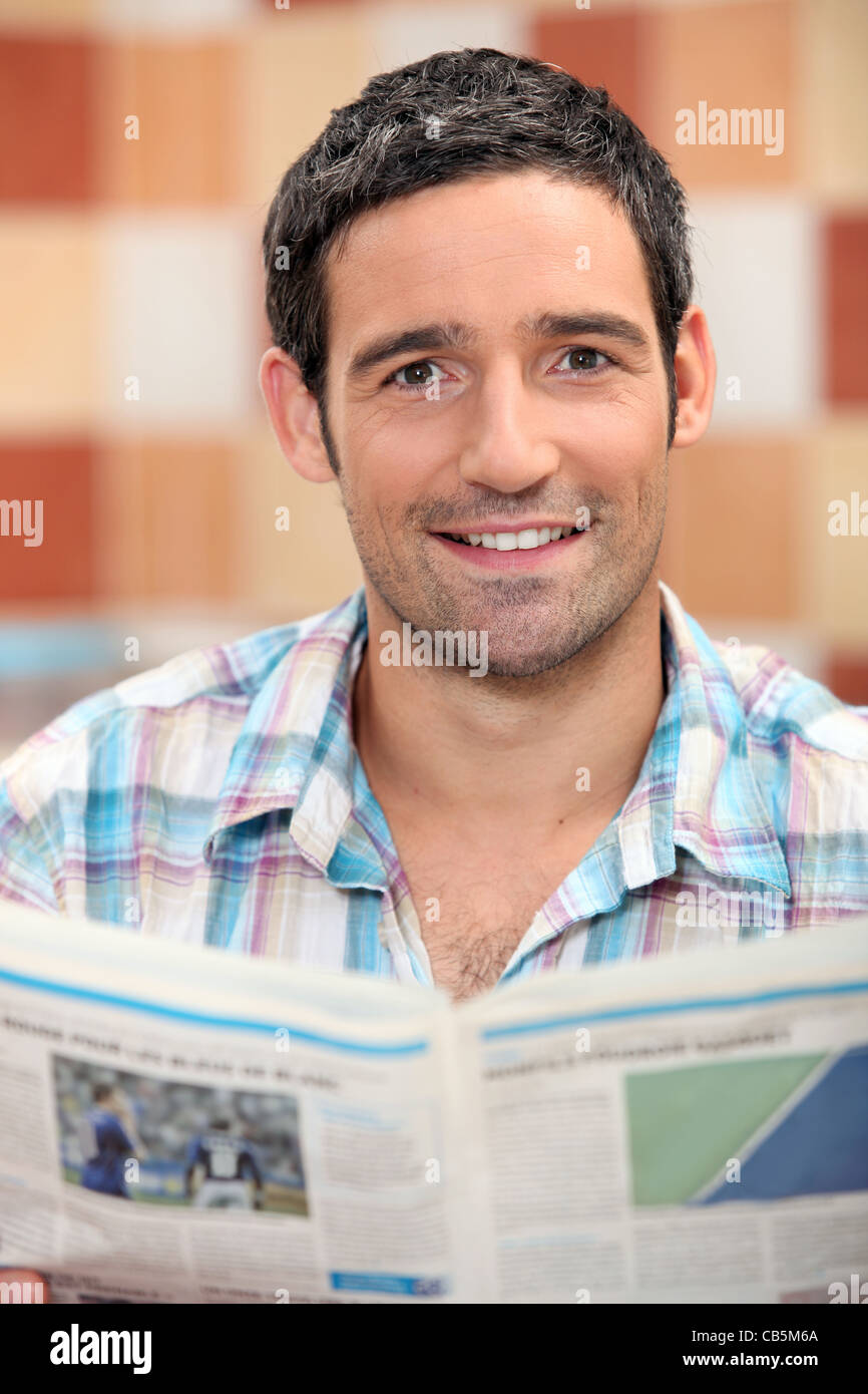 Smiling man reading a newspaper Stock Photo - Alamy