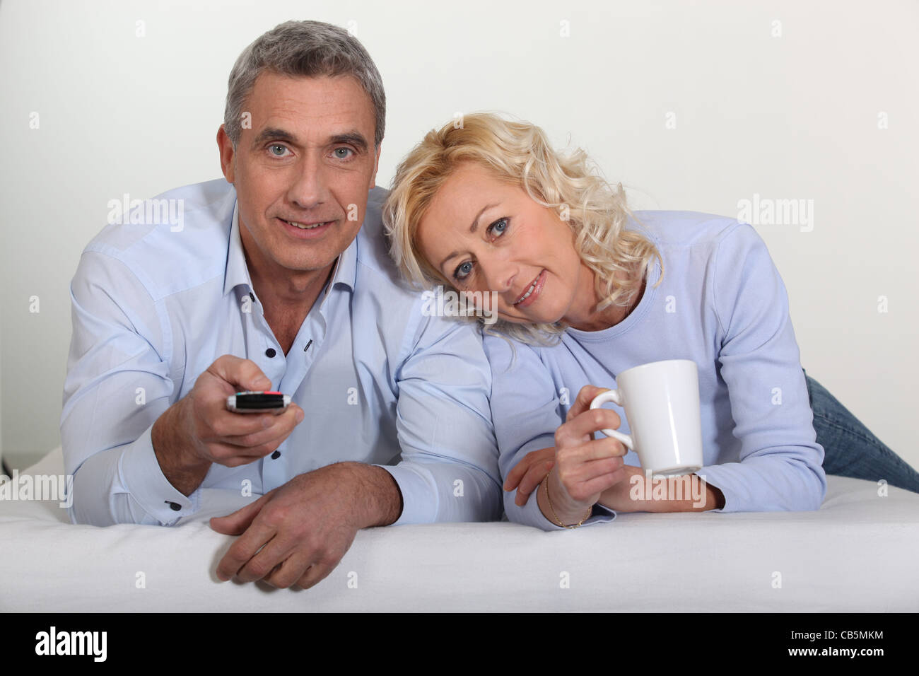 Middle-aged couple watching television in bed Stock Photo - Alamy