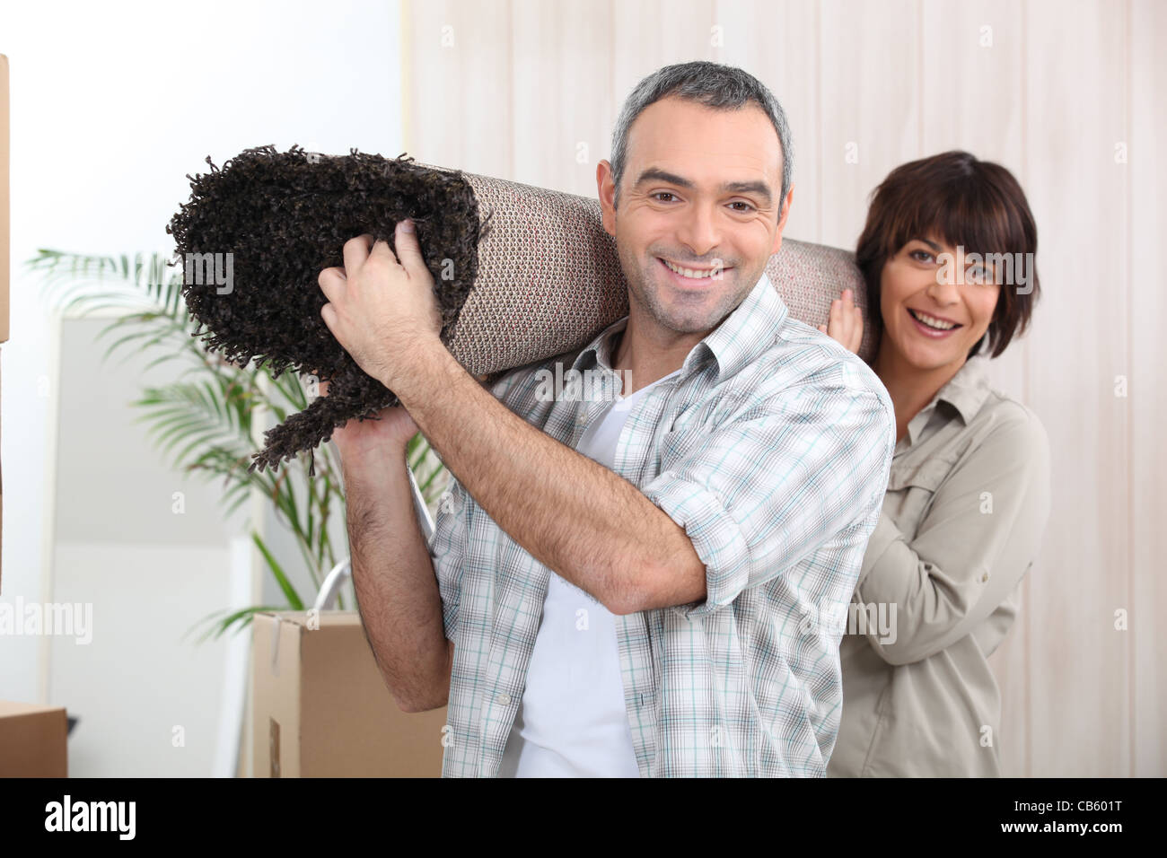 Couple carrying rug Stock Photo - Alamy