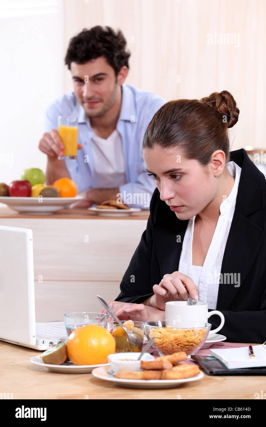 Career woman eating breakfast while working Stock Photo - Alamy
