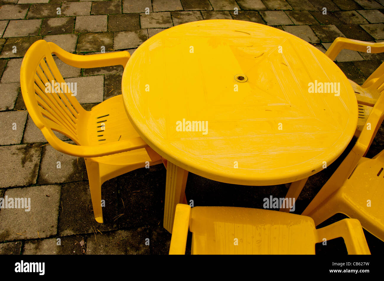 Yellow plastic table and chairs for outdoor recreation standing in ...