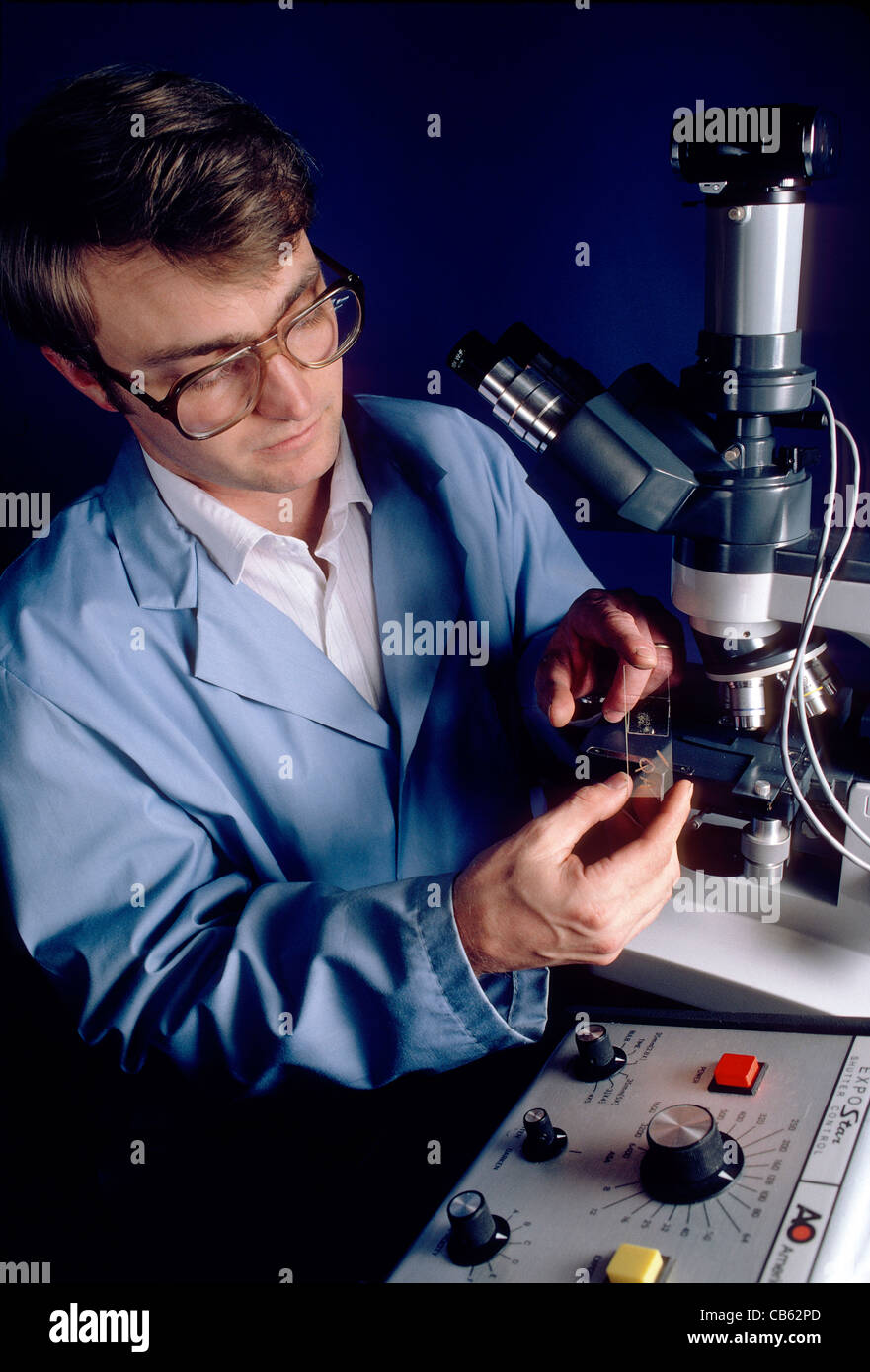 Scientist at a microscope in the quality control laboratory of a water ...
