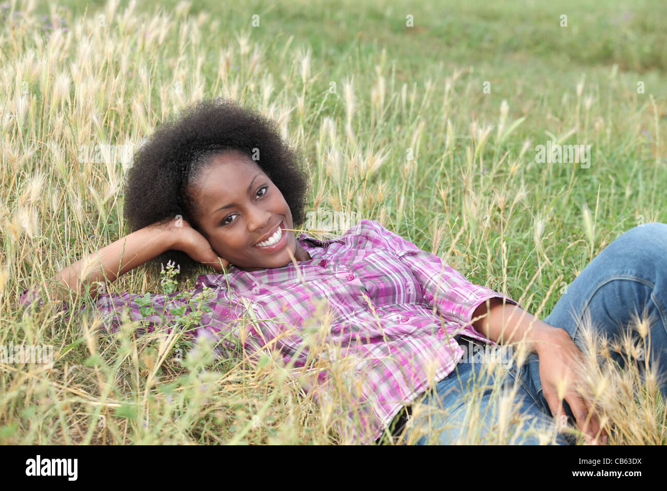 Woman relaxing laid in field Stock Photo - Alamy