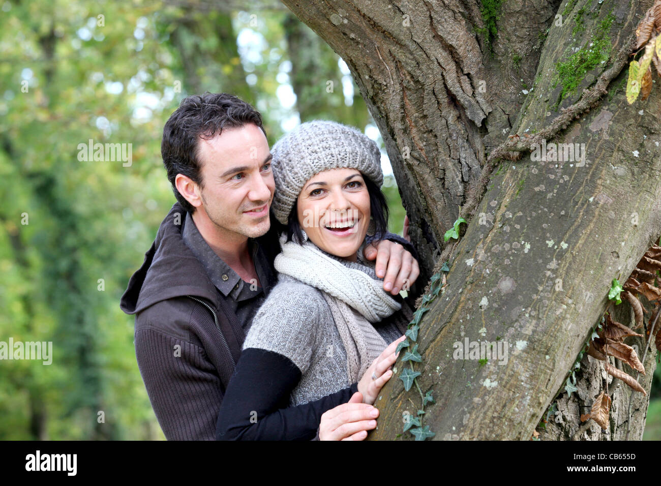 Couple stood by tree Stock Photo - Alamy