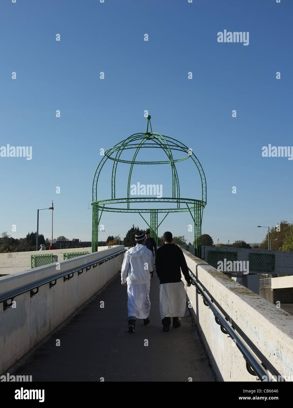 Young Muslim men walking across a pedestrian bridge in Luton Stock ...