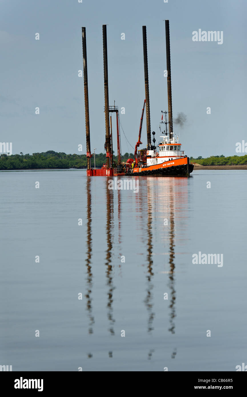 A small jack-up rig used for oil production being towed by a tug boat ...