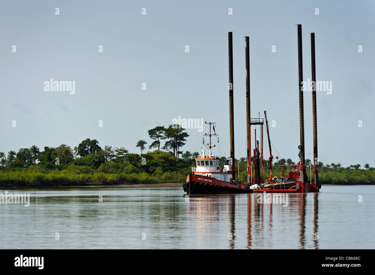 A small jack-up rig used for oil production being towed by a tug boat ...