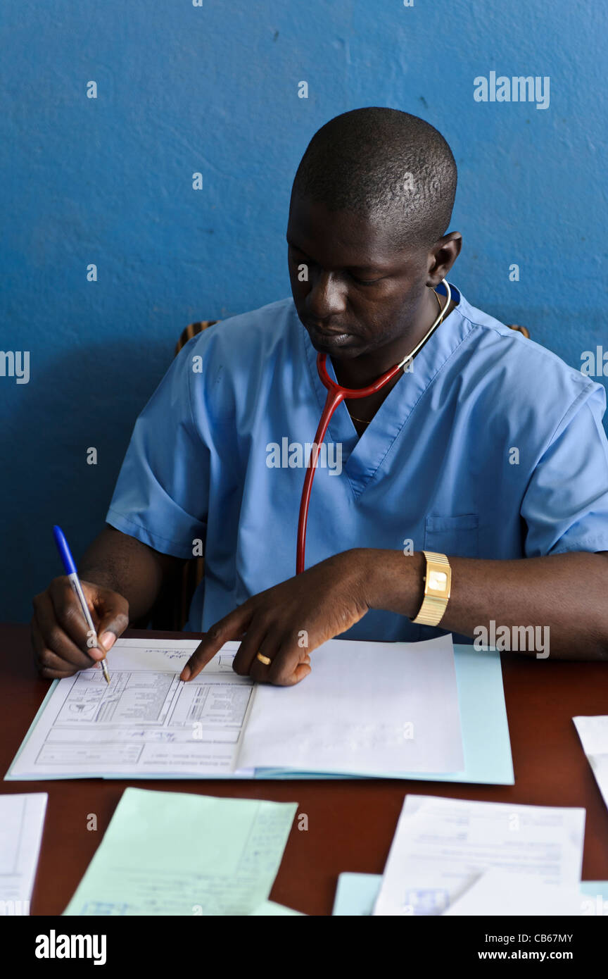 A young doctor writing patient notes in a hospital office, Freetown ...