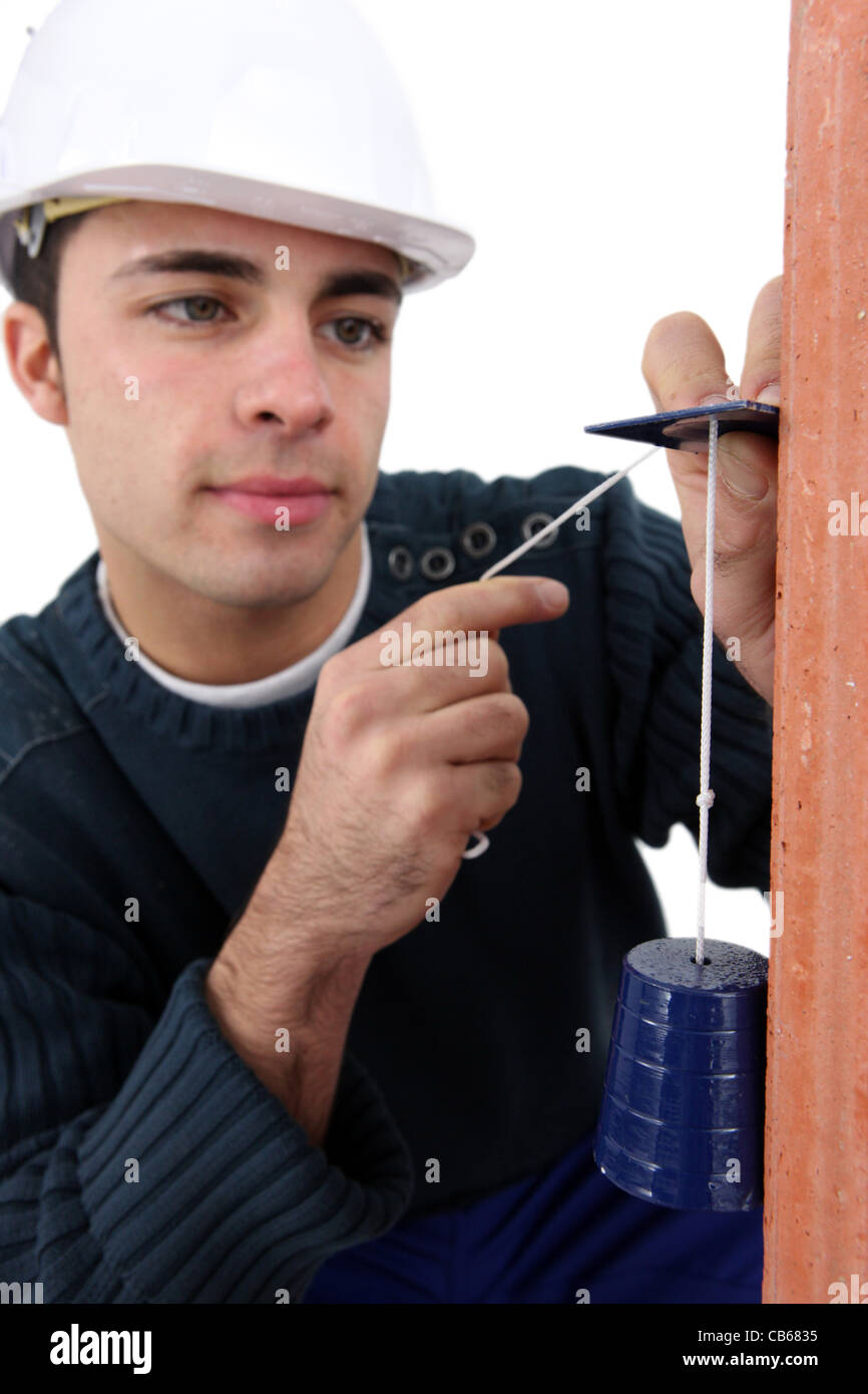 Mason with plumb line Stock Photo - Alamy