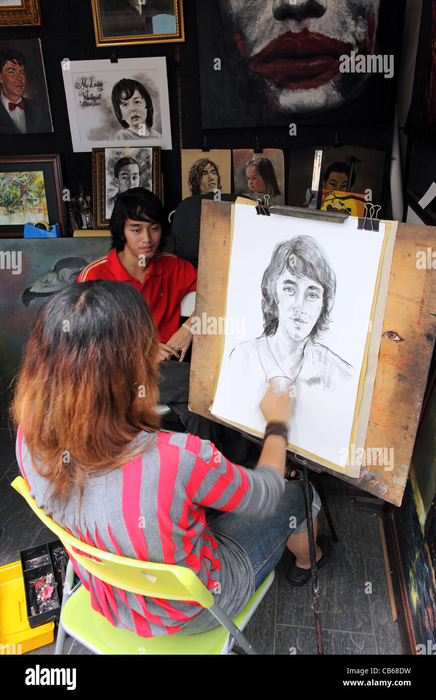 An artist at the Central Market sketches the portrait of a young man ...