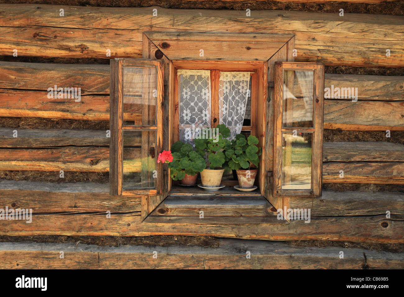 Open window with flowers on wooden cottage at the Open air Museum of ...