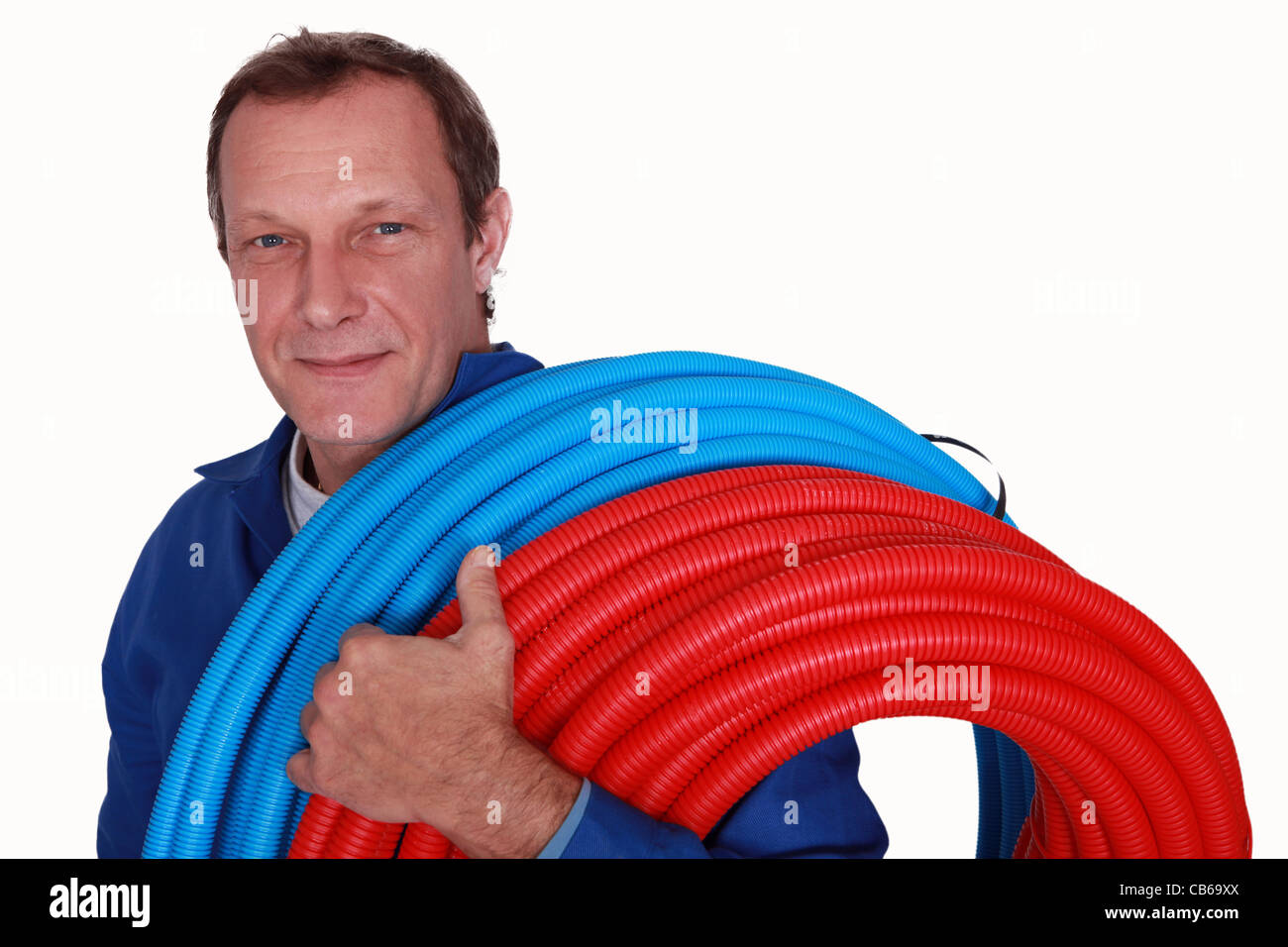 Plumber with reels of red and blue tubing Stock Photo - Alamy