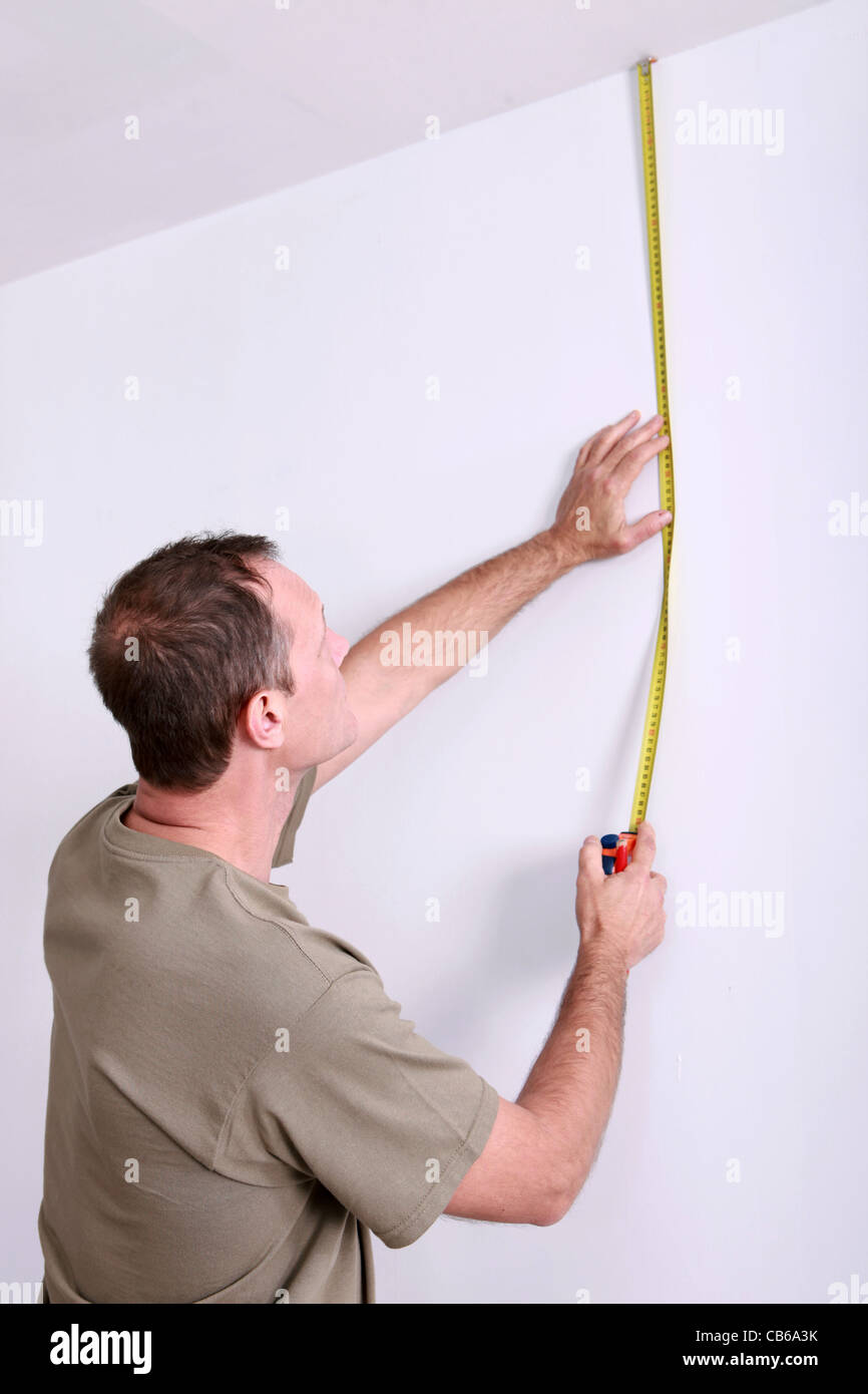 Man measuring wall Stock Photo - Alamy