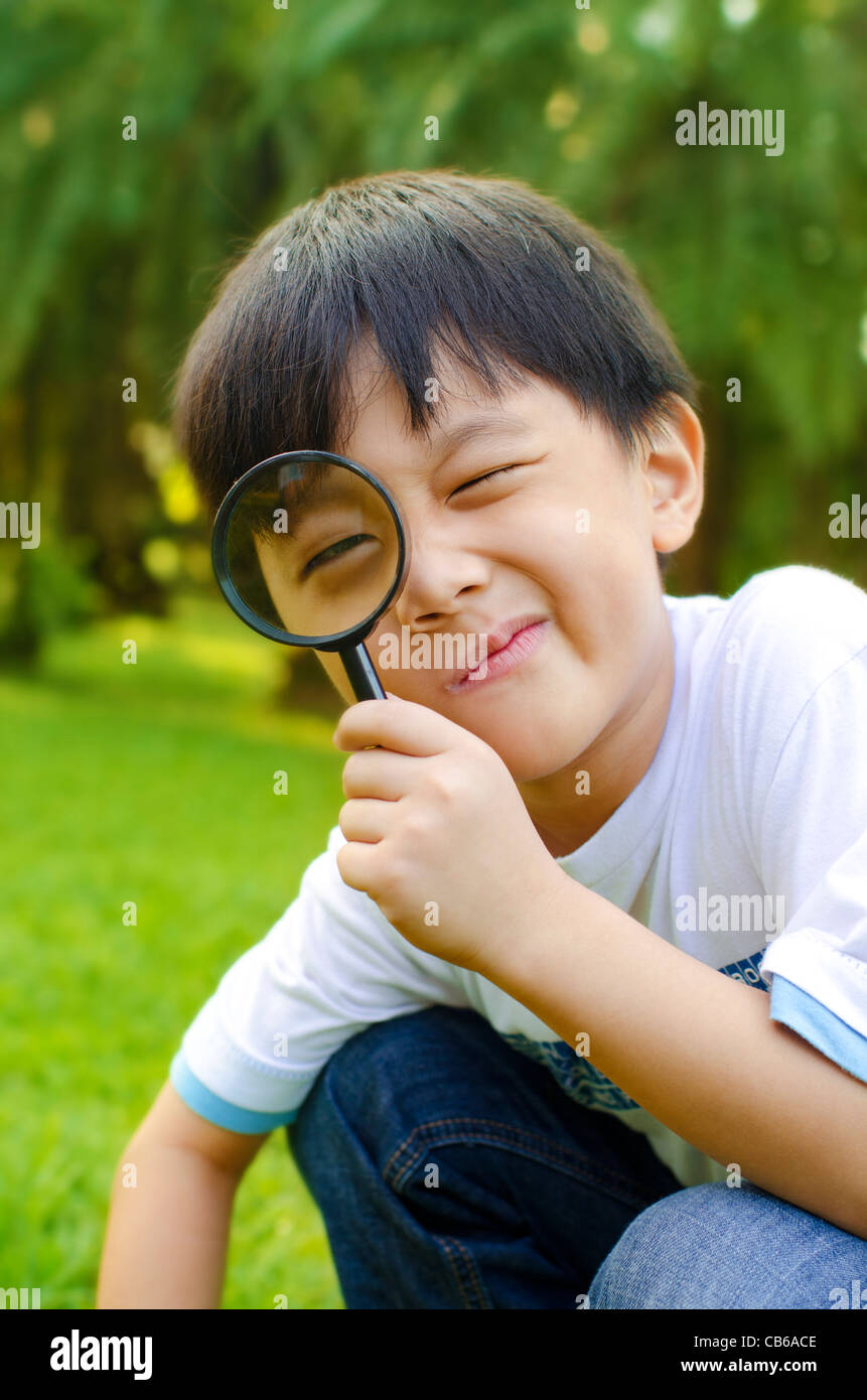 Little boy exploring nature by magnifier Stock Photo - Alamy