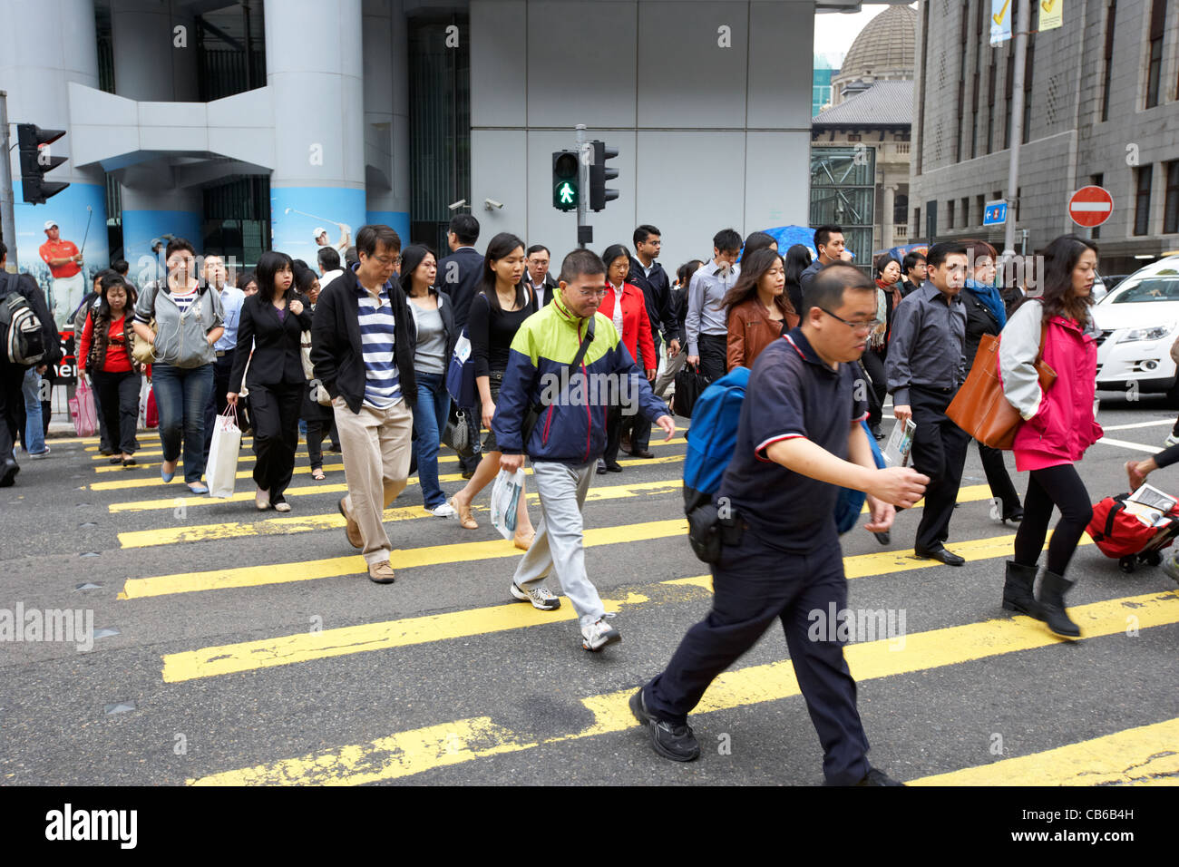 many chinese people crossing road in central district, hong kong island ...