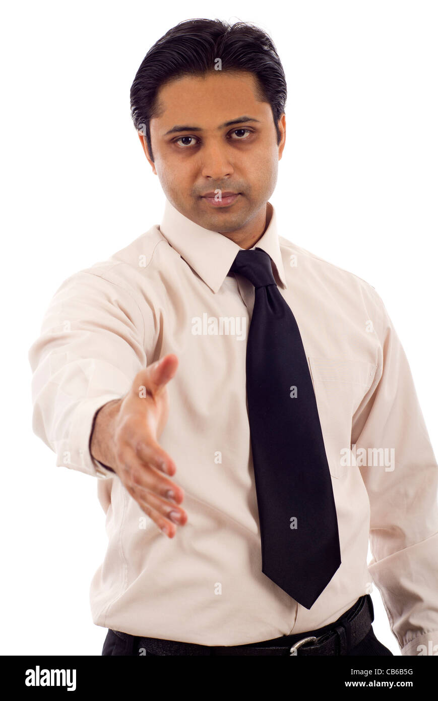 Serious looking Indian businessman offering a handshake isolated over ...