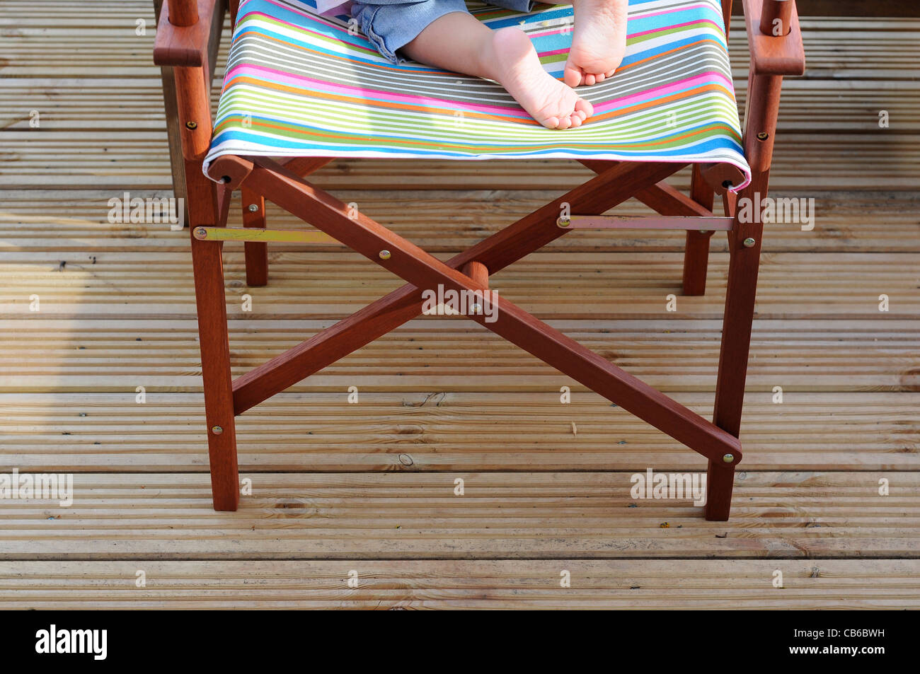 Young child's feet on an outdoor chair in summer Stock Photo - Alamy