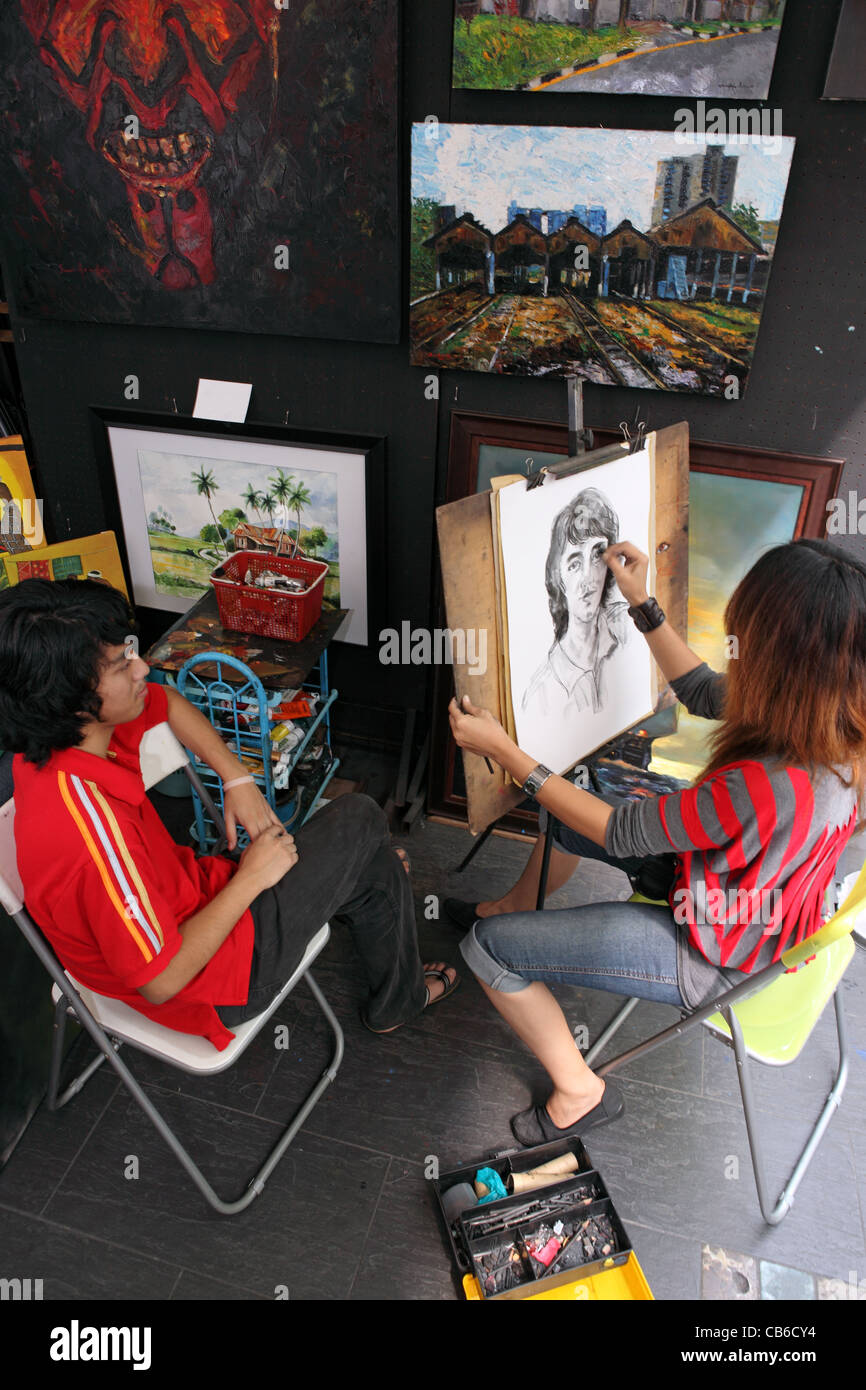 An artist at the Central Market sketches the portrait of a young man ...