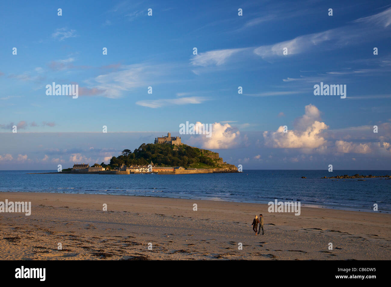 Young couple walking on beach with late summer evening sunshine on St ...