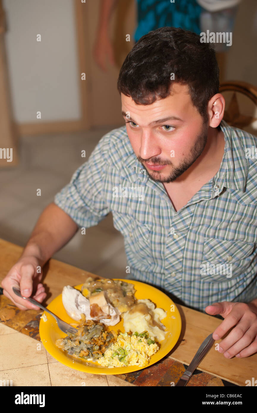 Young man eating dinner at home Stock Photo - Alamy