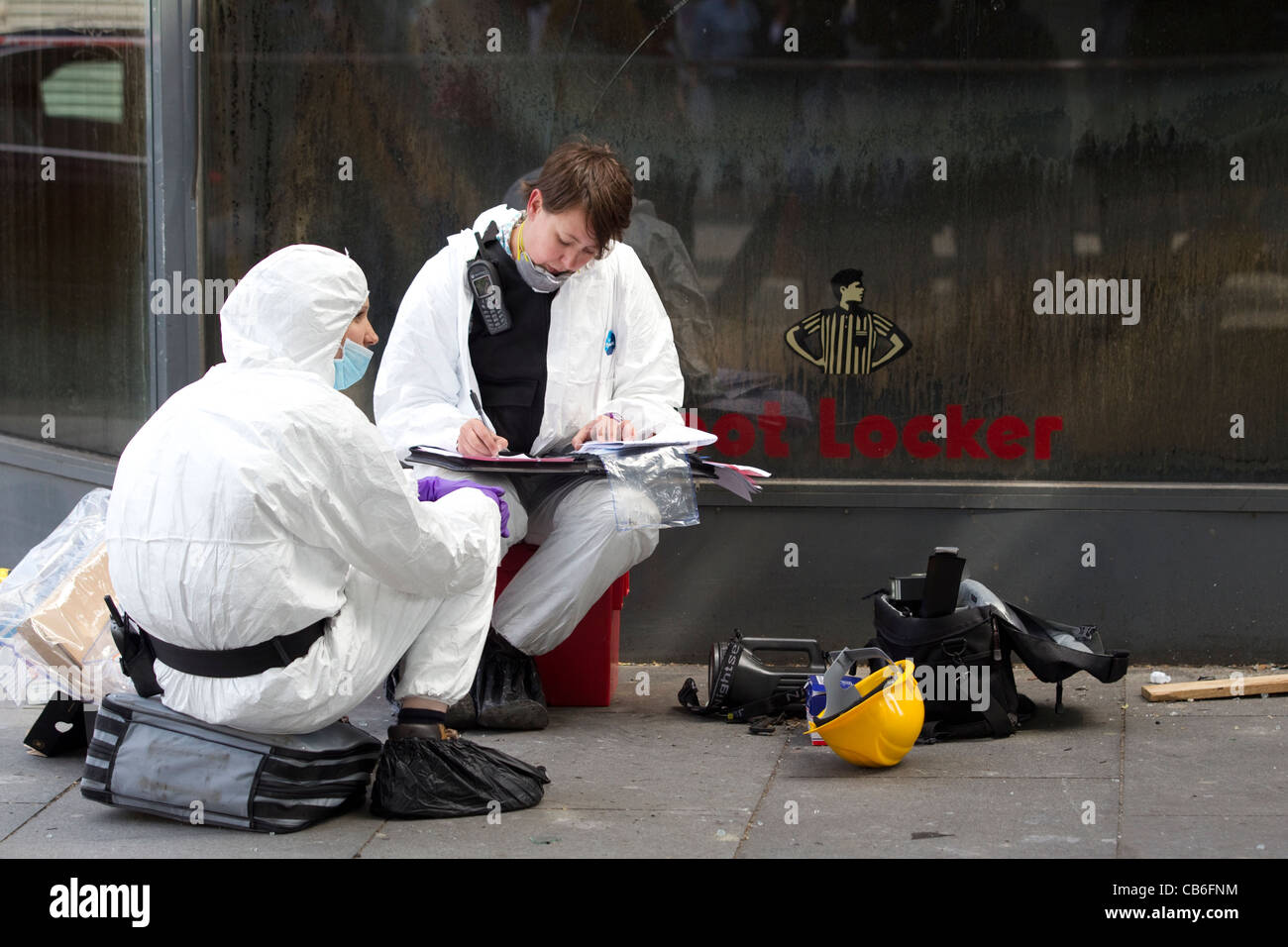 Police forensics search a burnt out Foot Locker sports wear store ...