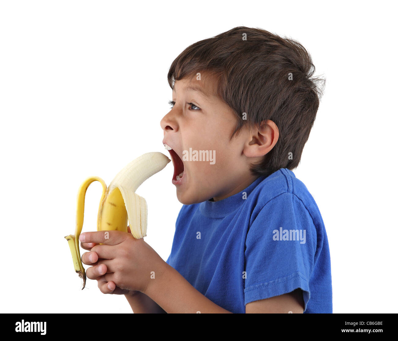 Young boy prepares to bite banana - on white background Stock Photo - Alamy