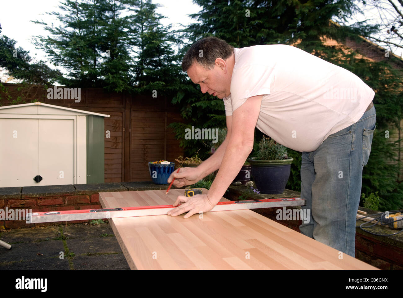 Tradesman using spirit level in preparation to fit worktop to new ...