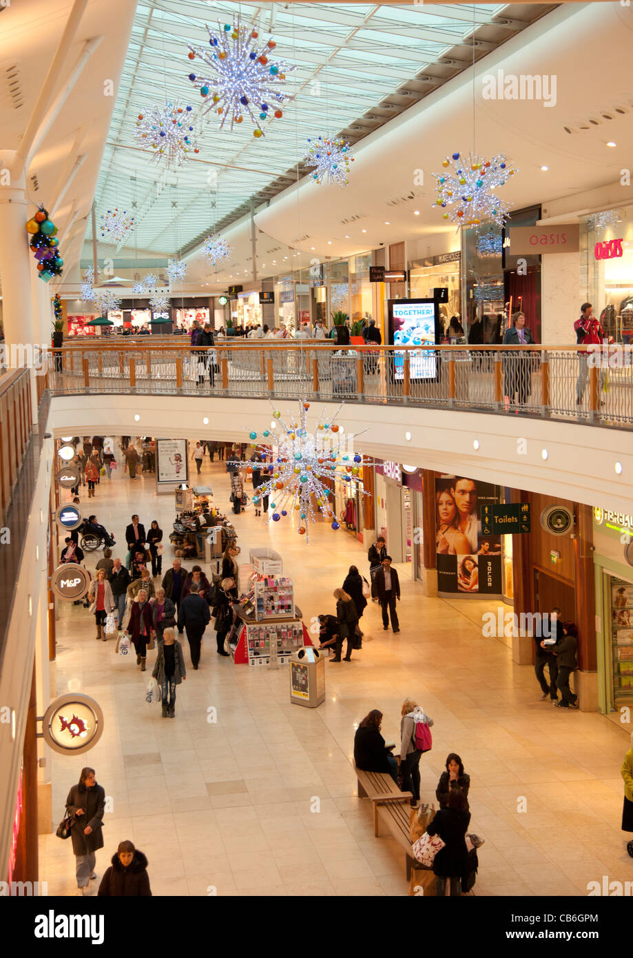 Shoppers stroll through a busy indoor shopping mall decorated for ...