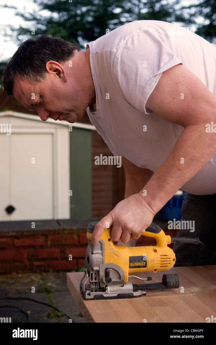 Tradesman using a jigsaw to cut worktop prior to fitting in new kitchen ...