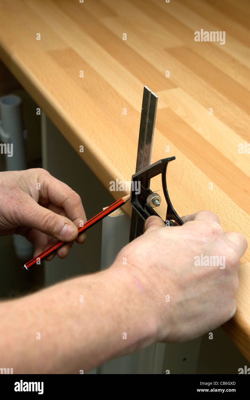 Tradesman taking measurements for fitting a new kitchen worktop ...