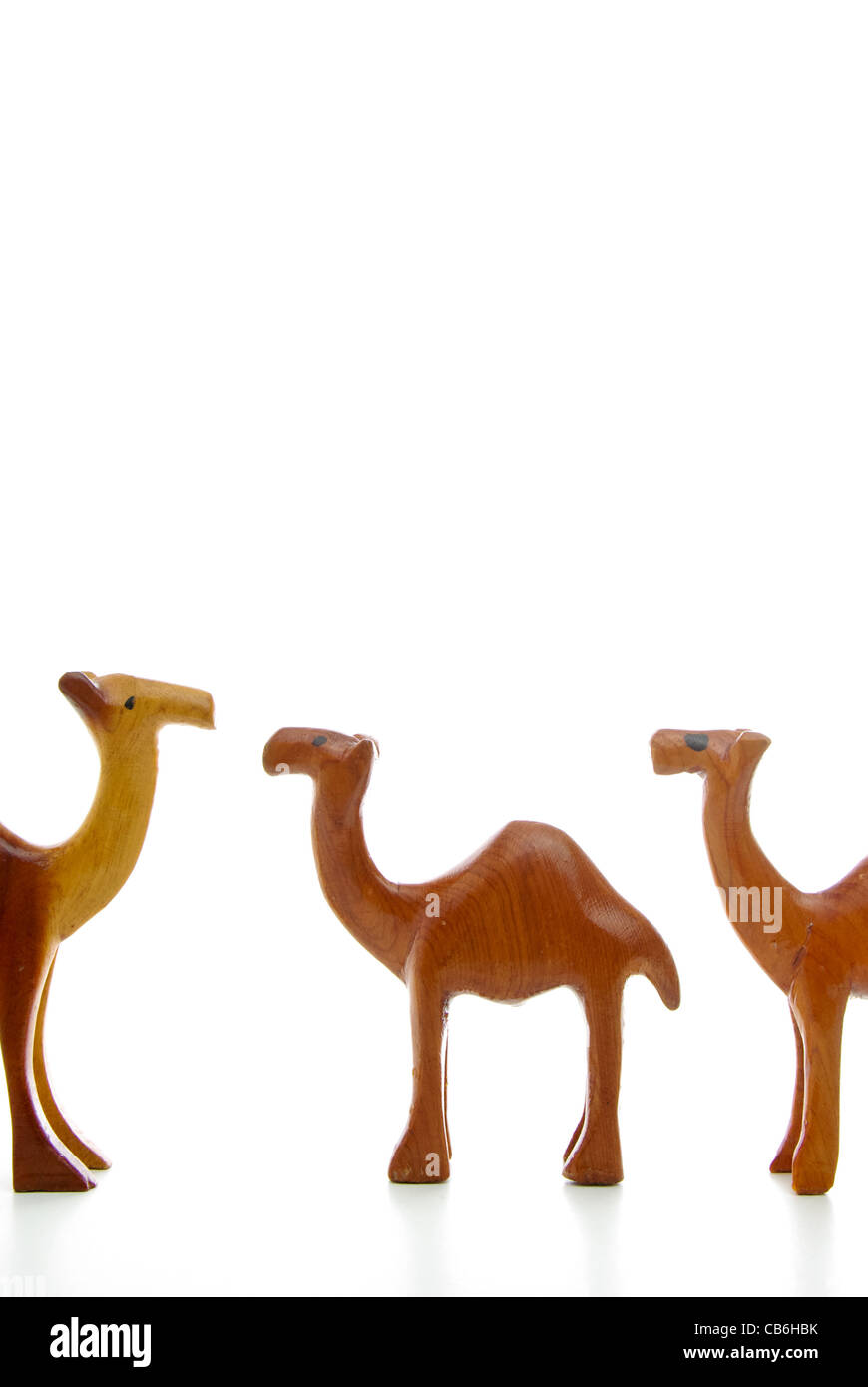 Three wooden camels isolated on a white background Stock Photo - Alamy