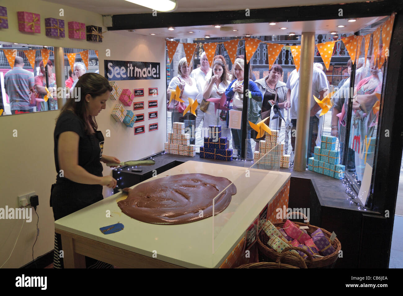 With a crowd of spectators, a young woman makes a batch of fudge by ...