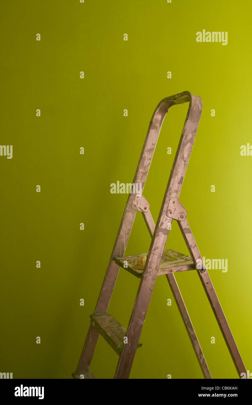 a construction ladder on a green wall Stock Photo - Alamy