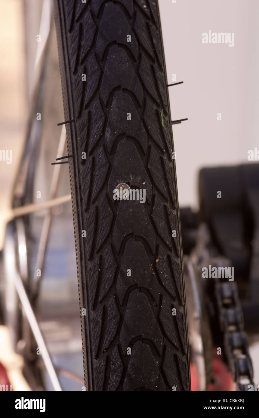 nail deeply penetrates bicycle wheel causing puncture Stock Photo - Alamy