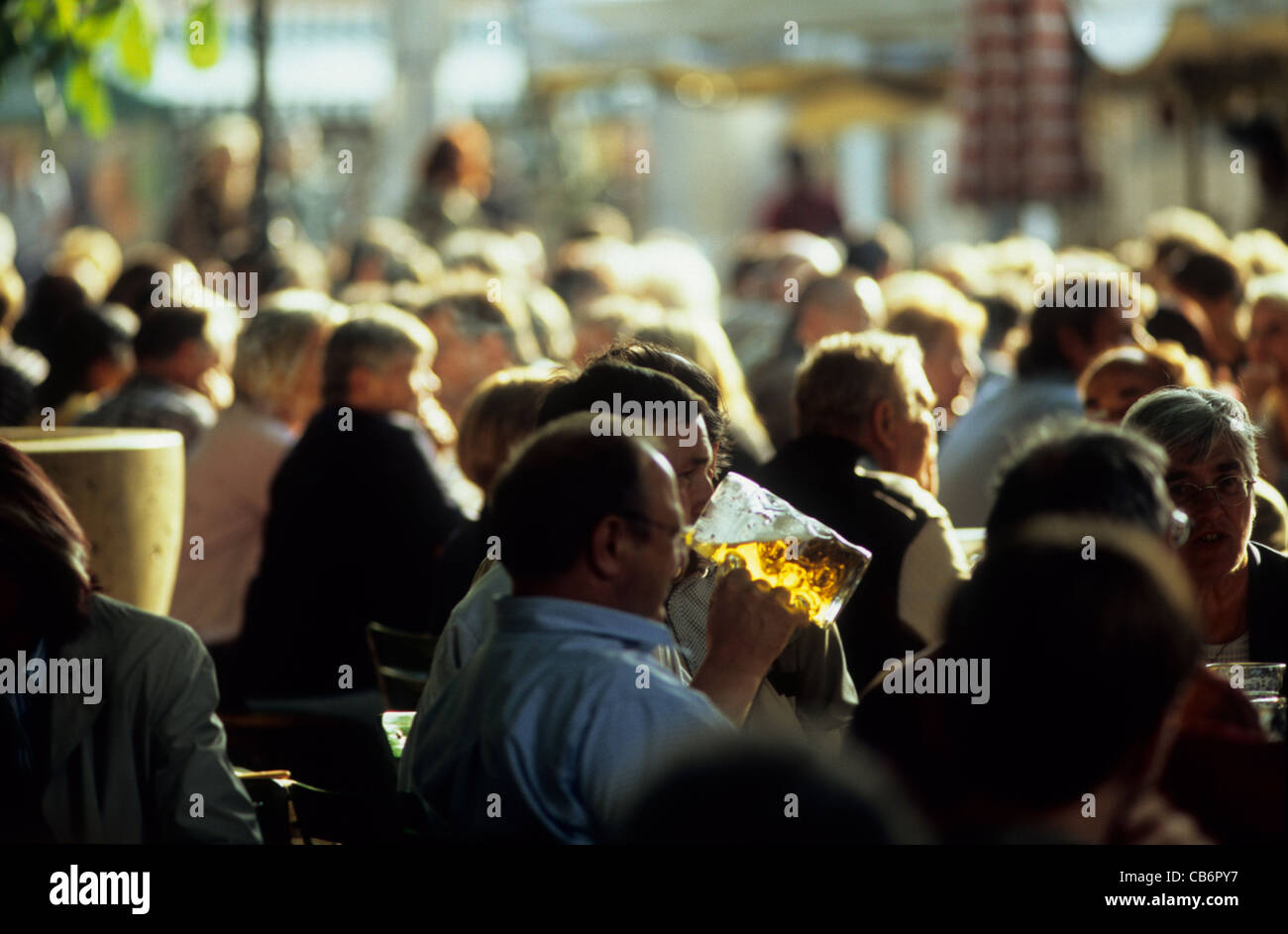 Crowd drinking in outdoor beergarden near Neues Rathaus, in Munich ...