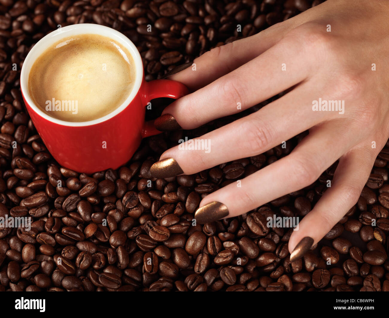 Closeup of woman's hand with a cup of coffe latte on coffee beans Stock ...