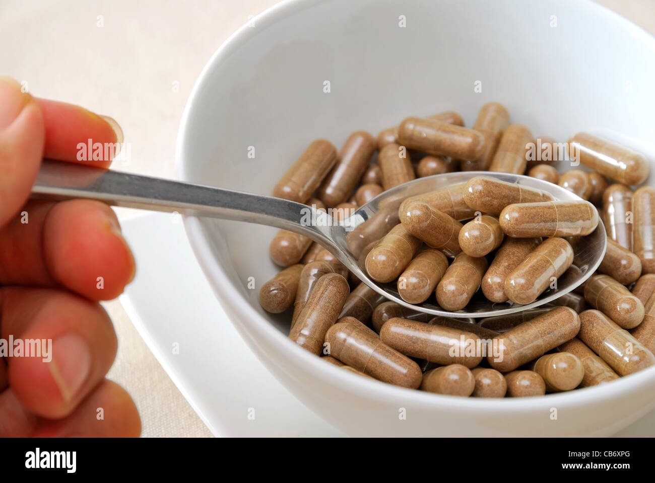 Spoon with medicinal capsules in white bowl Stock Photo - Alamy